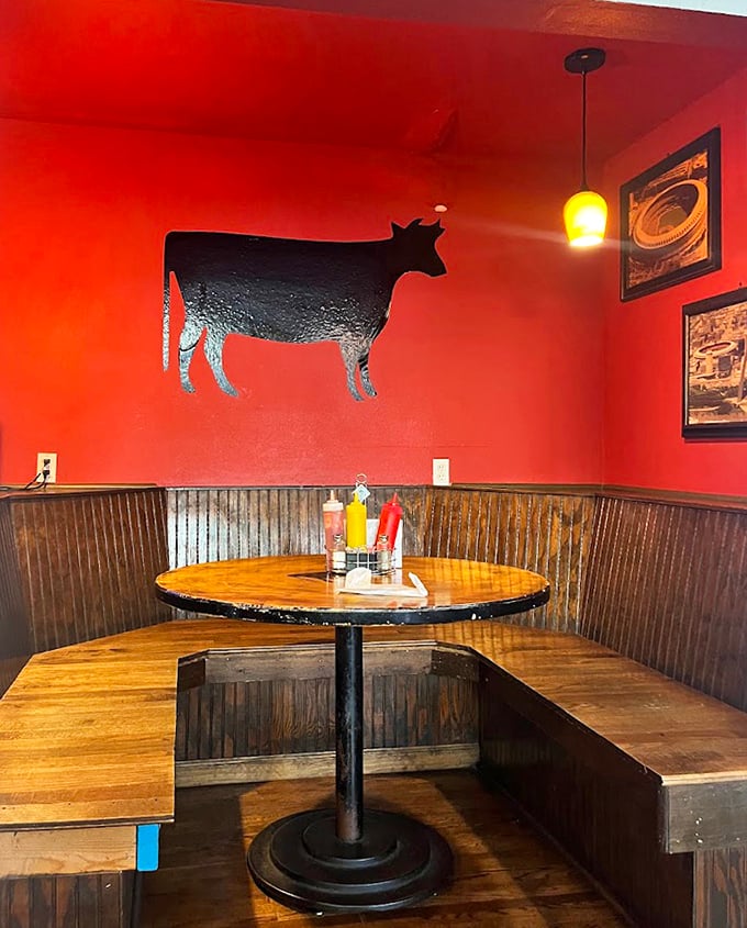 The cow silhouette against the red wall reminds you exactly why you came here: for serious beef business.