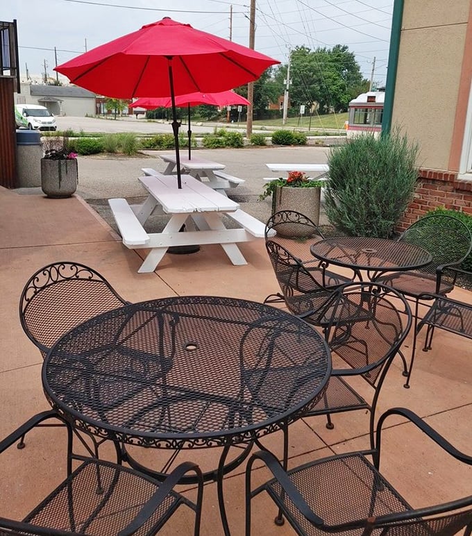 Outdoor seating with cheerful red umbrellas offers al fresco pizza enjoyment – because vitamin D makes everything taste even better.