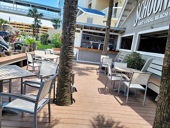 Palm trees growing through the deck aren't decorative choices—they were here first, and Schooners respectfully built around them. That's beach life.