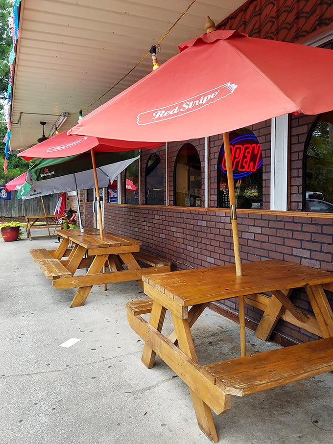 Outdoor picnic tables under red umbrellas offer a casual spot to savor authentic flavors while South Carolina's sunshine provides the ambiance.
