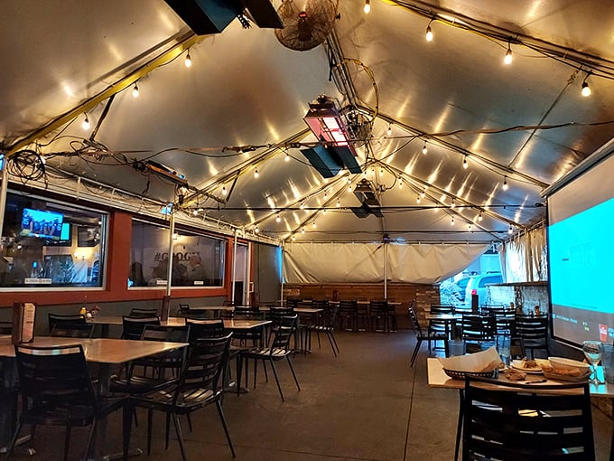 The covered patio offers year-round outdoor dining under twinkling lights—like eating wings at a casual wedding reception.