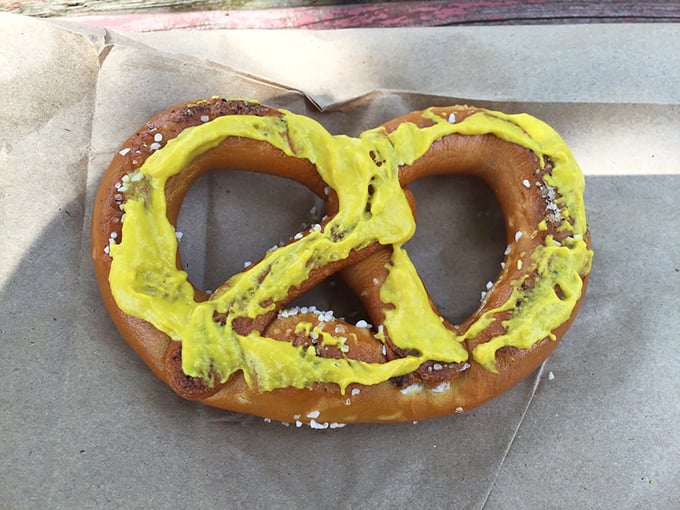That vibrant yellow mustard stripe across a traditional pretzel isn't just a condiment—it's a bold fashion statement in the world of handheld snacks.