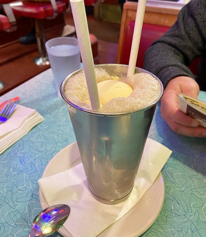 The root beer float—childhood nostalgia served in a frosty metal cup, complete with the impossible geometry of ice cream that refuses to sink.