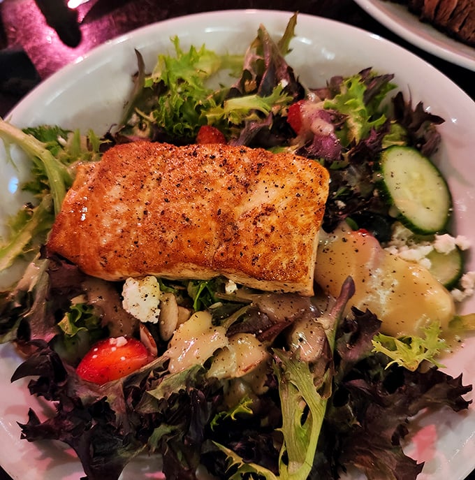 A perfectly seared salmon crowns a vibrant salad – proof that this steakhouse respects the ocean's bounty just as much as its land-based offerings.
