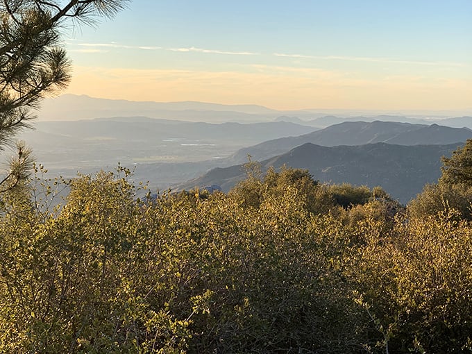 The layered mountains fade into misty blue distance—each ridge a different shade, as if the landscape is showing off its perfect ombré technique.