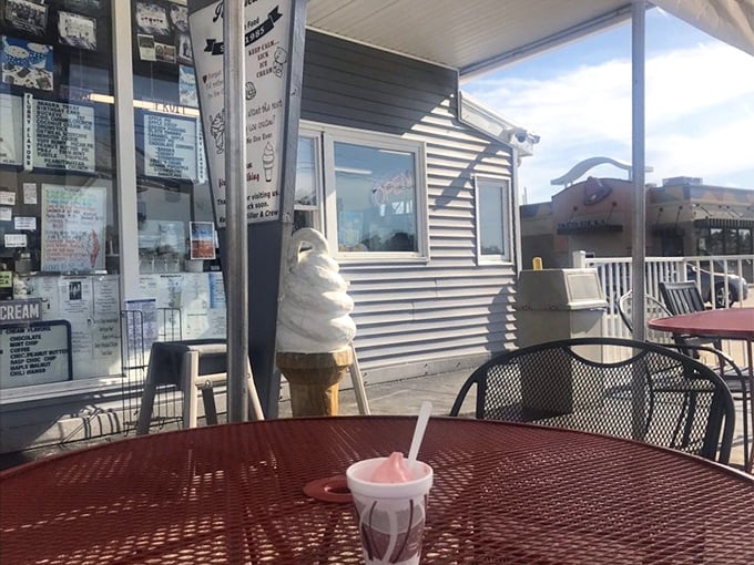 The outdoor seating area—where ice cream melts slightly slower than time itself. That towering soft serve cone in the background isn't just decoration.