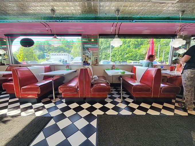 Window booths bathe diners in natural light, where the red vinyl seating pops against the checkerboard floor like a Norman Rockwell painting with better lighting.