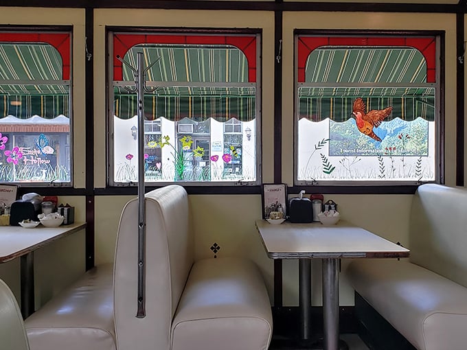 Cream-colored booths frame windows that showcase small-town America, turning every meal into dinner and a show.