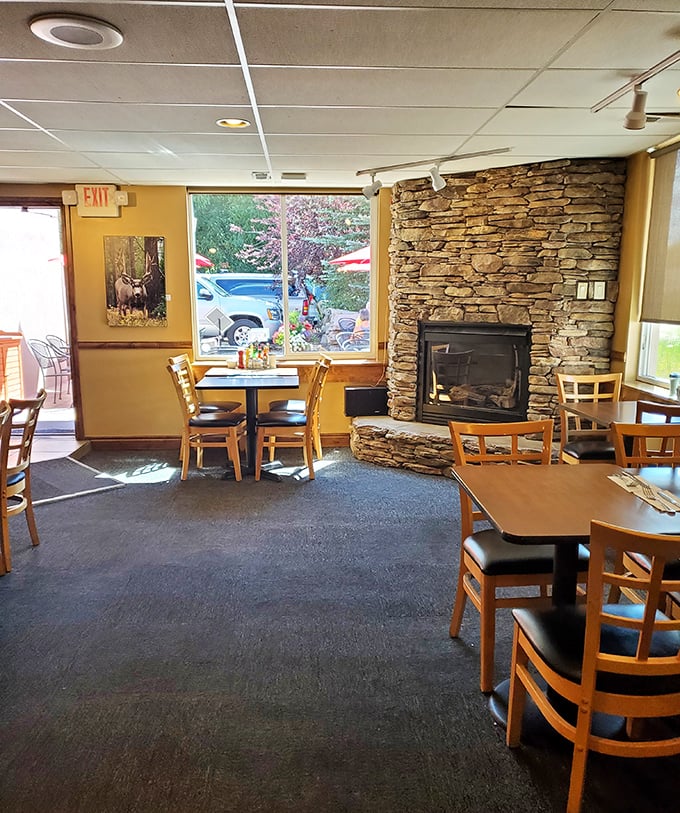 That stone fireplace isn't just decoration—it's the soul of this cozy corner where window seats offer views of Kamas life passing by.