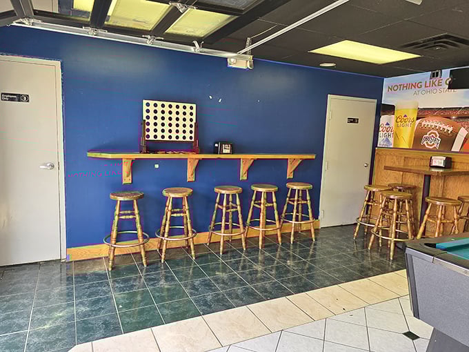 The blue wall and wooden stools create the perfect perch for pizza contemplation—or for waiting out the "five more minutes" your order needs.