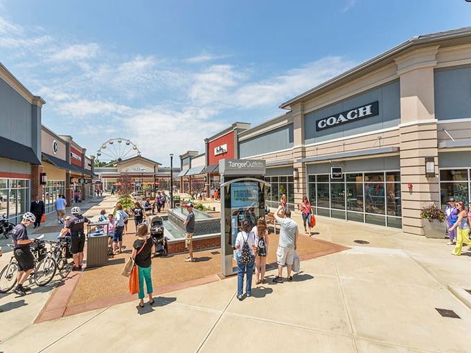 The central courtyard buzzes with the energy of successful shoppers comparing finds. That Coach store in the background has claimed many a credit card victim.