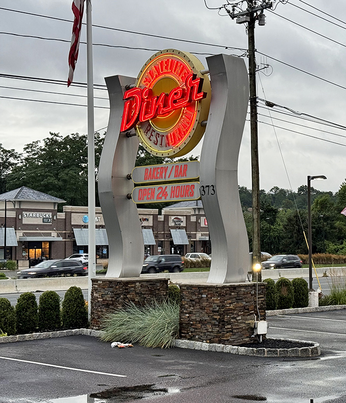 The neon sign doesn't just announce a diner – it's a beacon of hope for hungry travelers and a 24-hour promise of satisfaction.