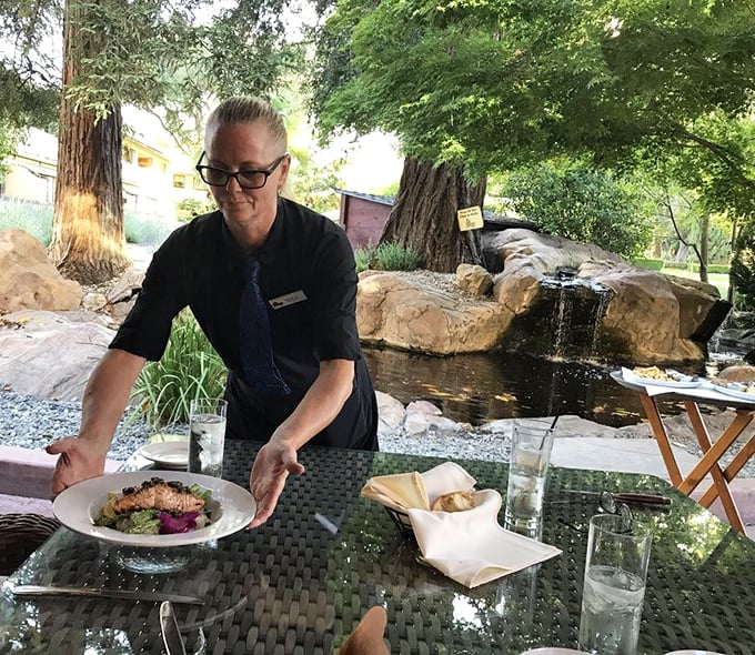 Outdoor dining with a view of the gardens – where the server delivers plates with the confidence of someone who knows you're about to be very happy.