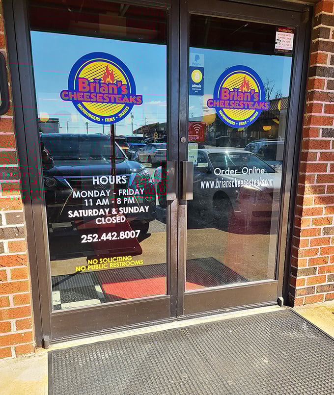 Business hours posted clearly—because knowing exactly when you can get your cheesesteak fix is information more valuable than gold.