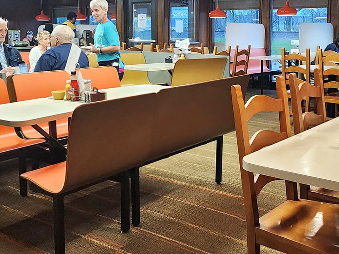 Orange booth seats and wooden chairs that have supported generations of diners. No designer furniture here, just honest comfort and function.