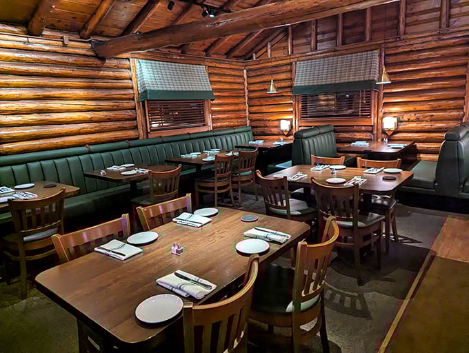 Green booths and wooden tables create intimate dining spaces that feel like you've scored the best cabin at summer camp—one with exceptional food service.