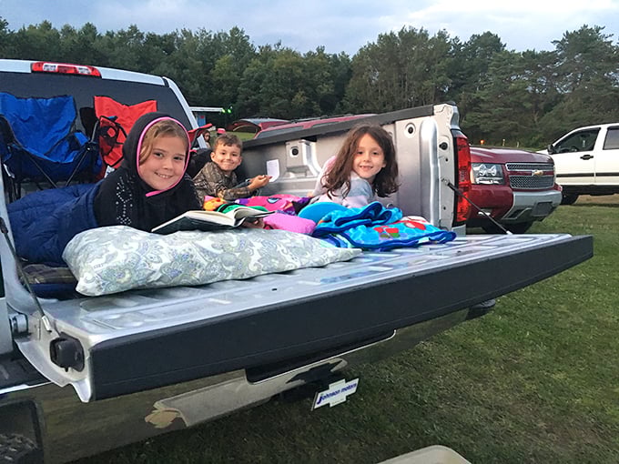 Kids nestled in truck beds with blankets and pillows—the original luxury box seats of outdoor cinema.