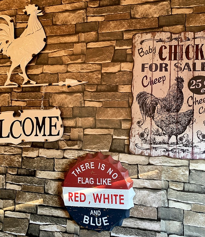 Rustic stone walls adorned with Americana – where "Welcome" signs and vintage chicken advertisements create the perfect backdrop for comfort food consumption.