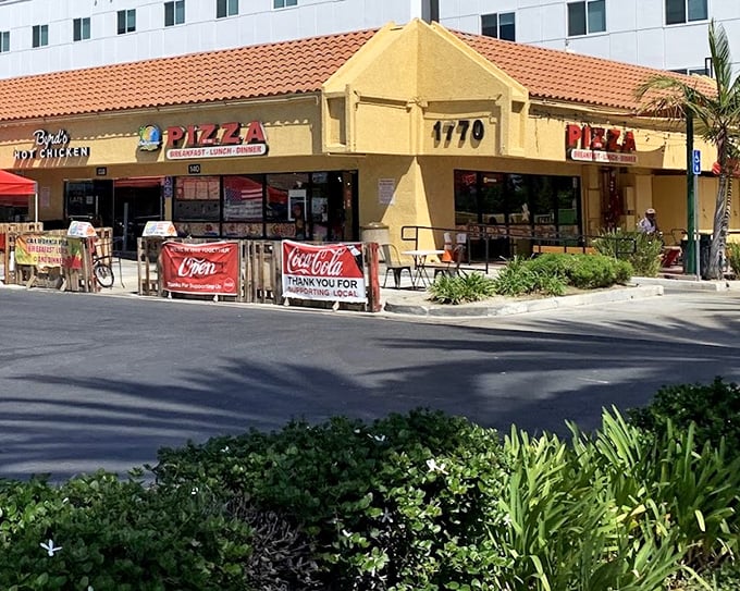 That sunny yellow building radiates the kind of warmth that makes every pizza taste like California sunshine.