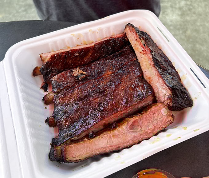 Ribs with that perfect pink smoke ring—visual evidence of the time-honored tradition of patience. The kind of food that makes conversation impossible except for appreciative grunts.