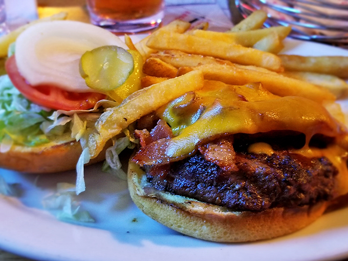 A burger that's dressed better than most people on a Friday night—layers of melty cheese, bacon, and fresh veggies creating the perfect bite.