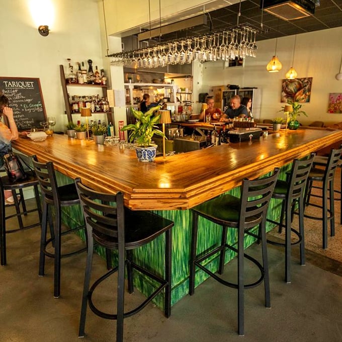The bar's distinctive green glow isn't just on-brand—it creates an almost underwater ambiance perfect for a seafood-focused restaurant.
