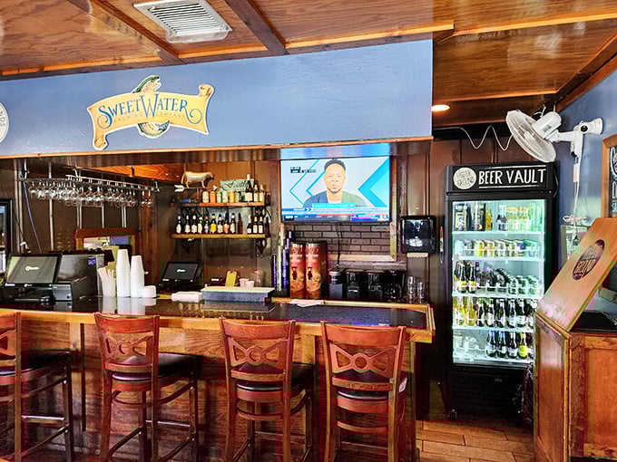 The bar area whispers "stay awhile" with craft beers on display—because great burgers deserve worthy liquid companions.