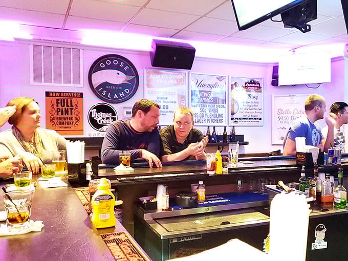 The bar's purple glow creates that perfect "it's 5 o'clock somewhere" ambiance where craft beers and battlefield tales flow with equal enthusiasm.