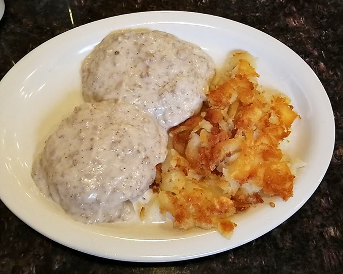 Biscuits smothered in country gravy alongside crispy hash browns—a plate that whispers "nap time" even as you eagerly dig in.