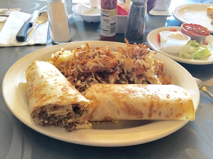 A breakfast burrito that's clearly been to the gym, bulging with fillings and flanked by hash browns that look like they're auditioning for a supporting actor award.