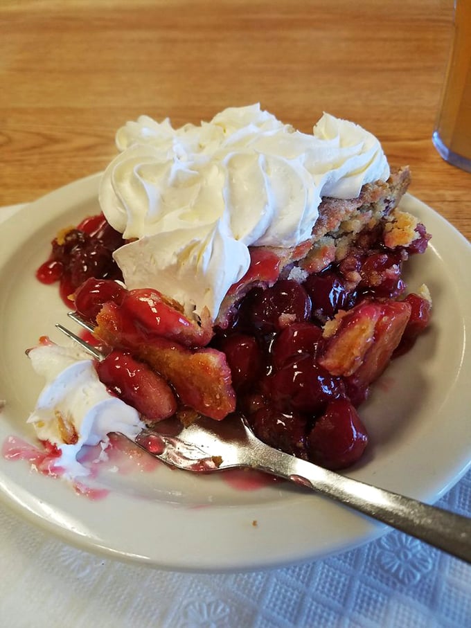 Cherry pie with a dollop of whipped cream—the sweet-tart filling peeking through the crust like a ruby treasure.