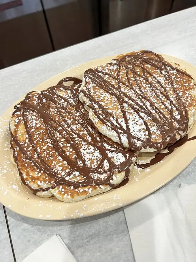 Chocolate chip pancakes drizzled with chocolate sauce—because sometimes breakfast should feel like you're getting away with something naughty.