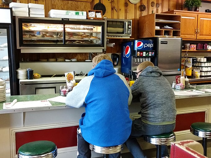 The counter seats—where solo diners become regulars and regulars become family. That pie display case isn't helping anyone's diet plans.