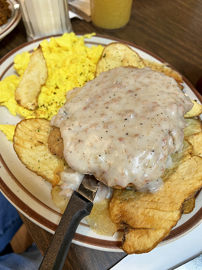 Country fried steak smothered in gravy with a side of sunshine-yellow eggs – cardiac concern meets comfort food paradise.