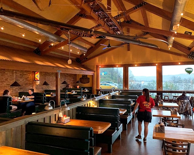 High ceilings, exposed beams, and river views create the perfect backdrop for the serious business of enjoying smoked meat without distraction.