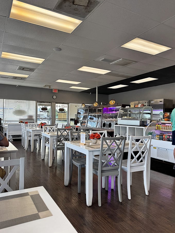 Clean, bright, and inviting—the dining area's white tables and cross-back chairs create the perfect canvas for the colorful food experience ahead.