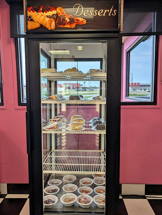 The dessert case stands like a trophy display of sweet achievements—each shelf promising a different path to happiness.