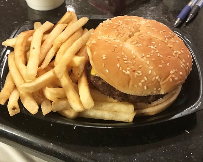 A double cheeseburger and fries on a black tray—proof that sometimes the simplest pleasures deliver the most profound satisfaction.