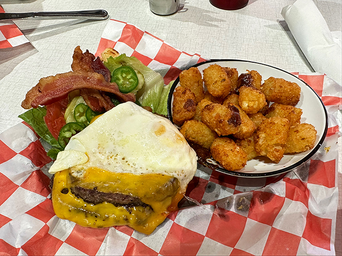 This isn't just a burger – it's a masterpiece of excess. The runny egg creates a sauce that turns those golden tots into vehicles for pure joy.