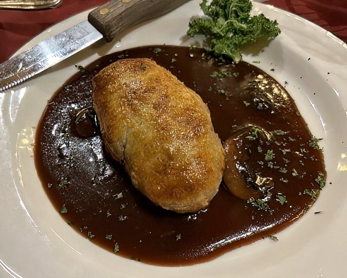 Duck Wellington swimming in rich sauce—a dish that makes you want to write thank-you notes to whoever invented gravy.