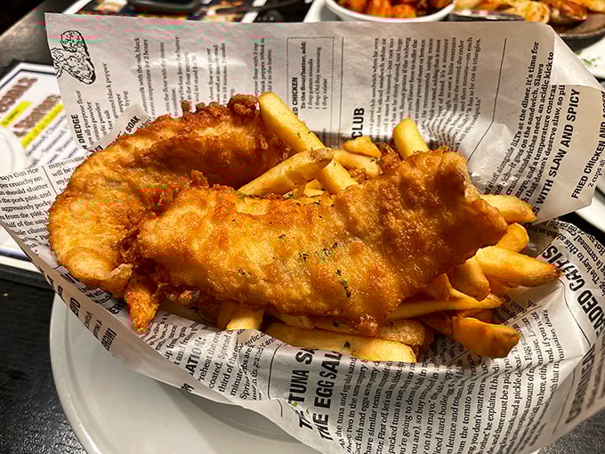 This fish and chips doesn't just swim to your table—it practically leaps, golden and crispy, nestled in newspaper like the catch of the day it truly is.