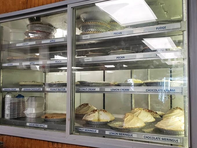 The pie case—where life-altering decisions are made daily. Each perfectly labeled pie waits patiently for its moment of glory at your table.
