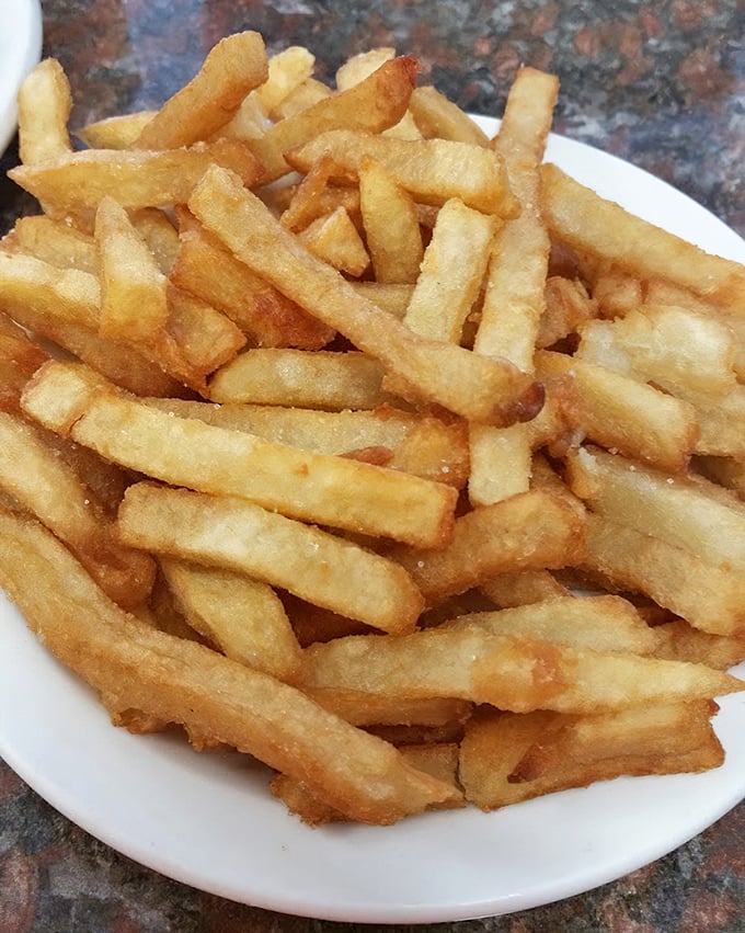 French fries that achieve the impossible balance of crispy exterior and fluffy interior—the supporting actors that often steal the show.