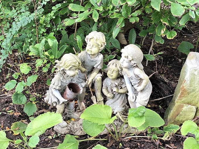Garden statuary that captures childhood curiosity perfectly—these stone children look as enchanted by the garden as every human visitor.