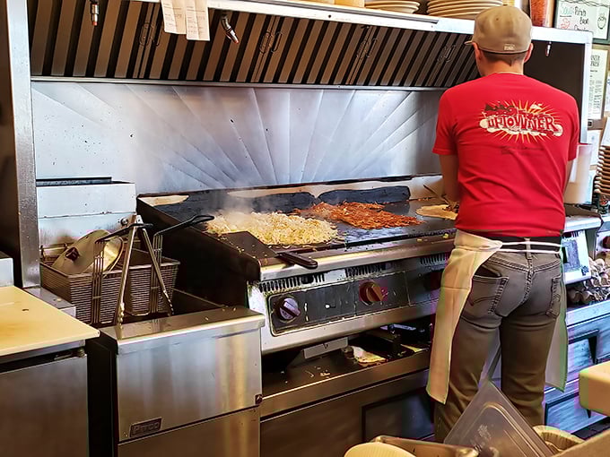 Breakfast alchemy in action—where potatoes transform into golden hashbrowns under the watchful eye of a griddle master.