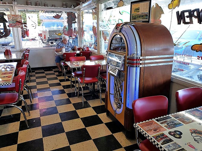 The vintage jukebox stands sentinel in the corner, ready to provide the soundtrack to your meal—because every great burger deserves its own theme music.