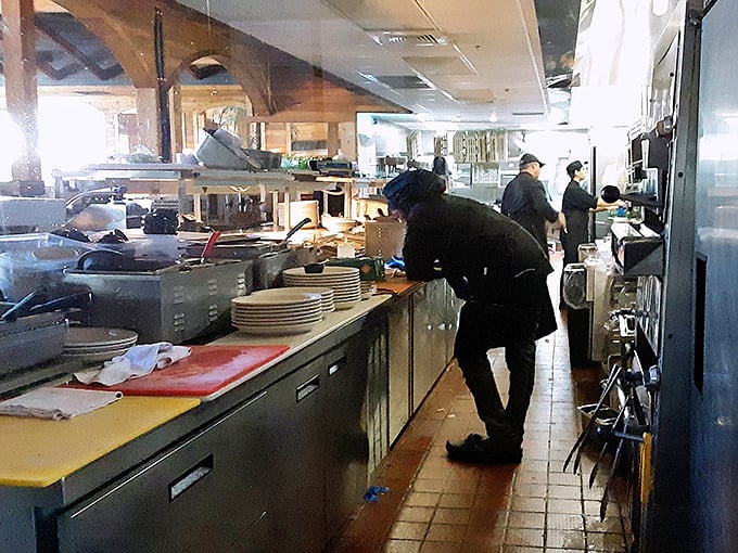 A glimpse into the kitchen reveals the choreographed chaos where culinary magic happens before reaching your eagerly waiting table.