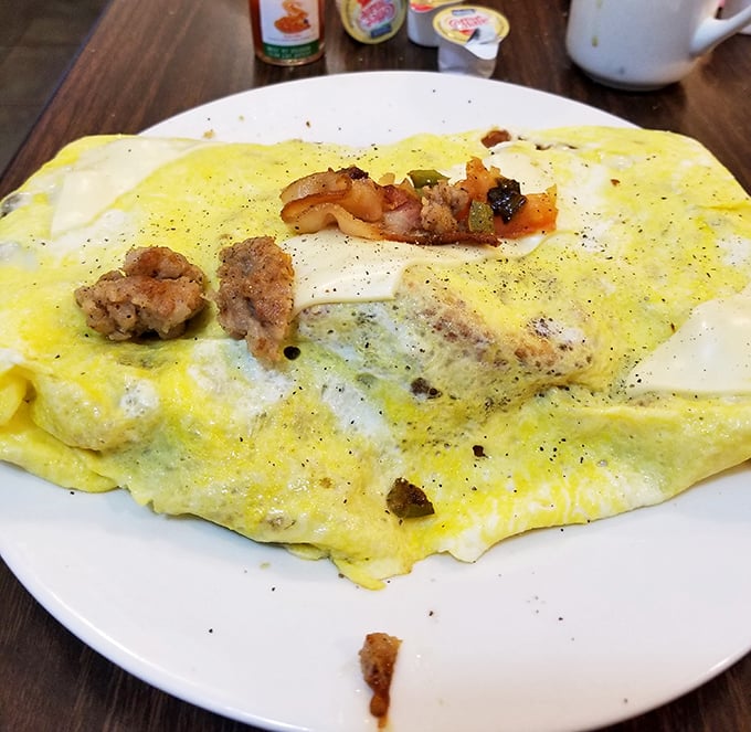 This omelet isn't just breakfast—it's a fluffy yellow canvas painted with savory ingredients that turn morning into an occasion.