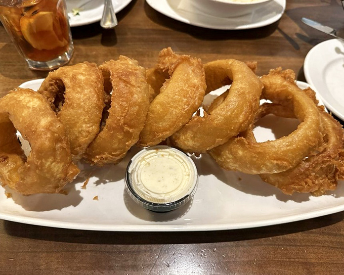 These onion rings aren't just fried—they're golden halos of crispy perfection that make you forget vegetables are supposed to be good for you.