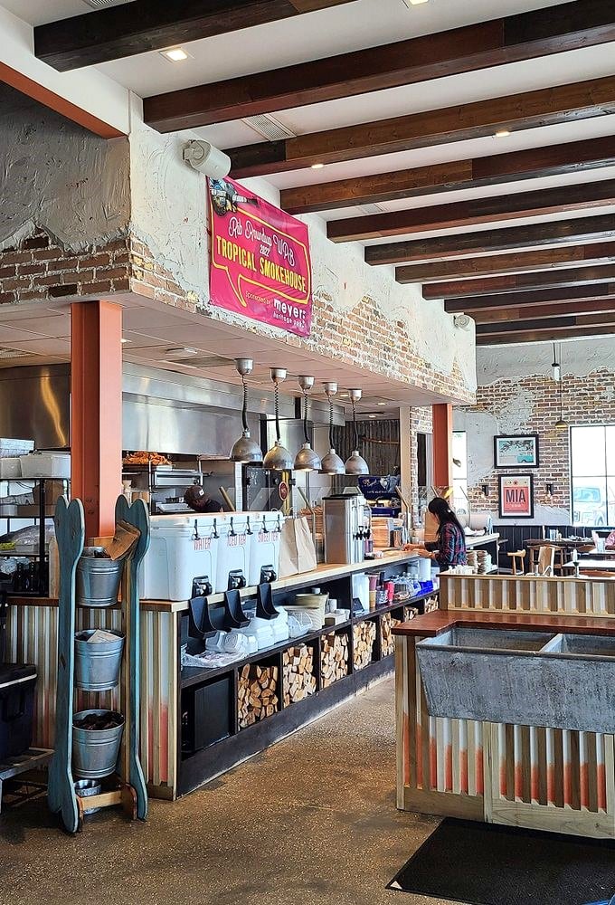 Rustic-industrial charm meets BBQ functionality—exposed brick, wooden beams, and the promise of smoked delights to come.